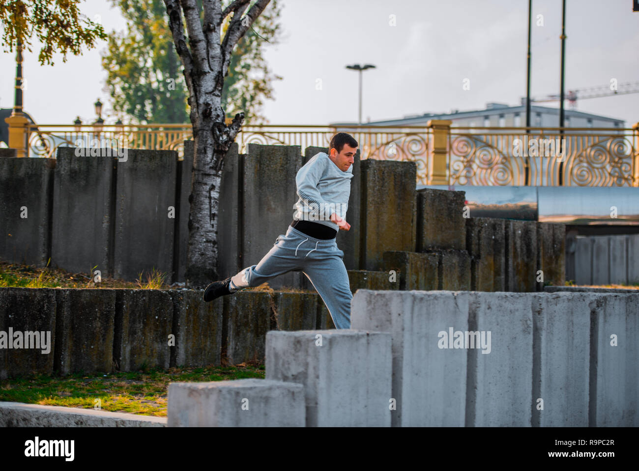 Sportsman jumping over obstacles while exercising parkour Stock Photo ...