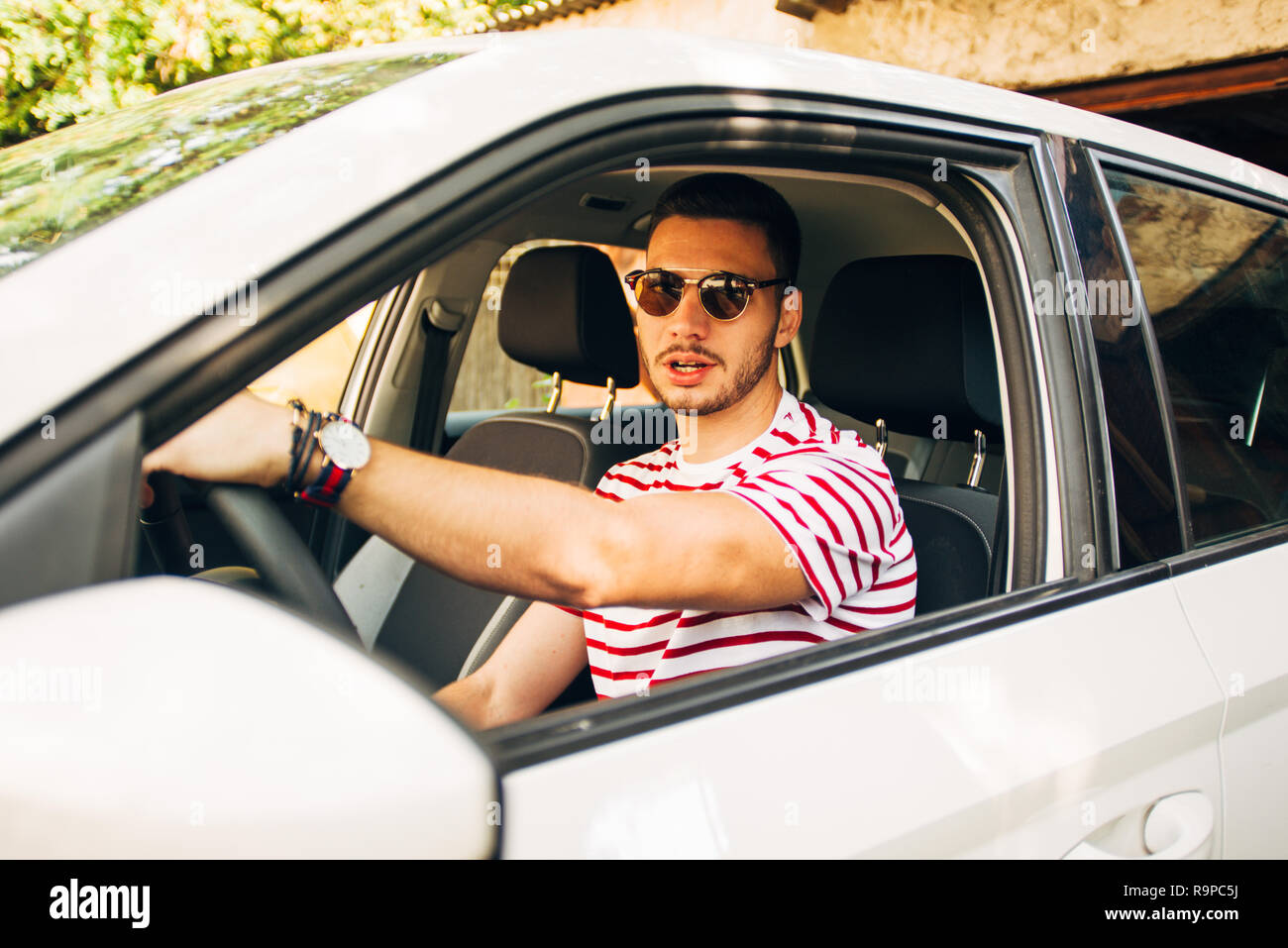 Young man in his car preparing to drive with his window open Stock ...