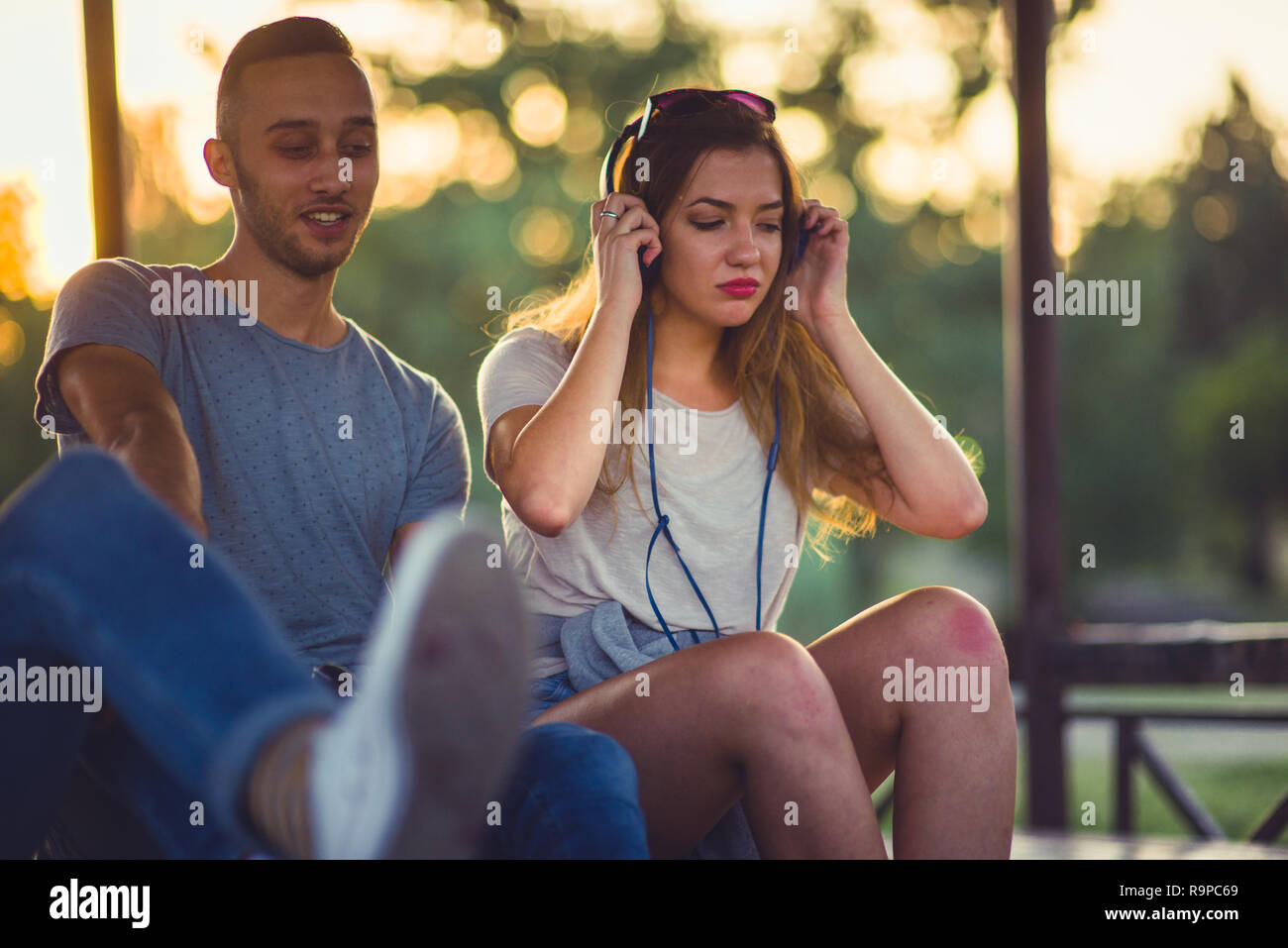 Two careless people are enjoying the sunset view in the park and ...