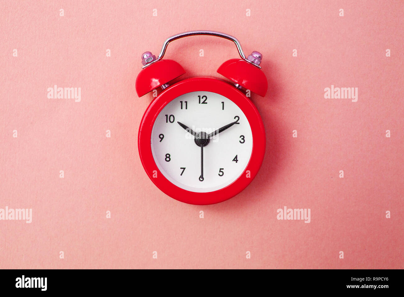 Red background and red alarm clock Stock Photo - Alamy