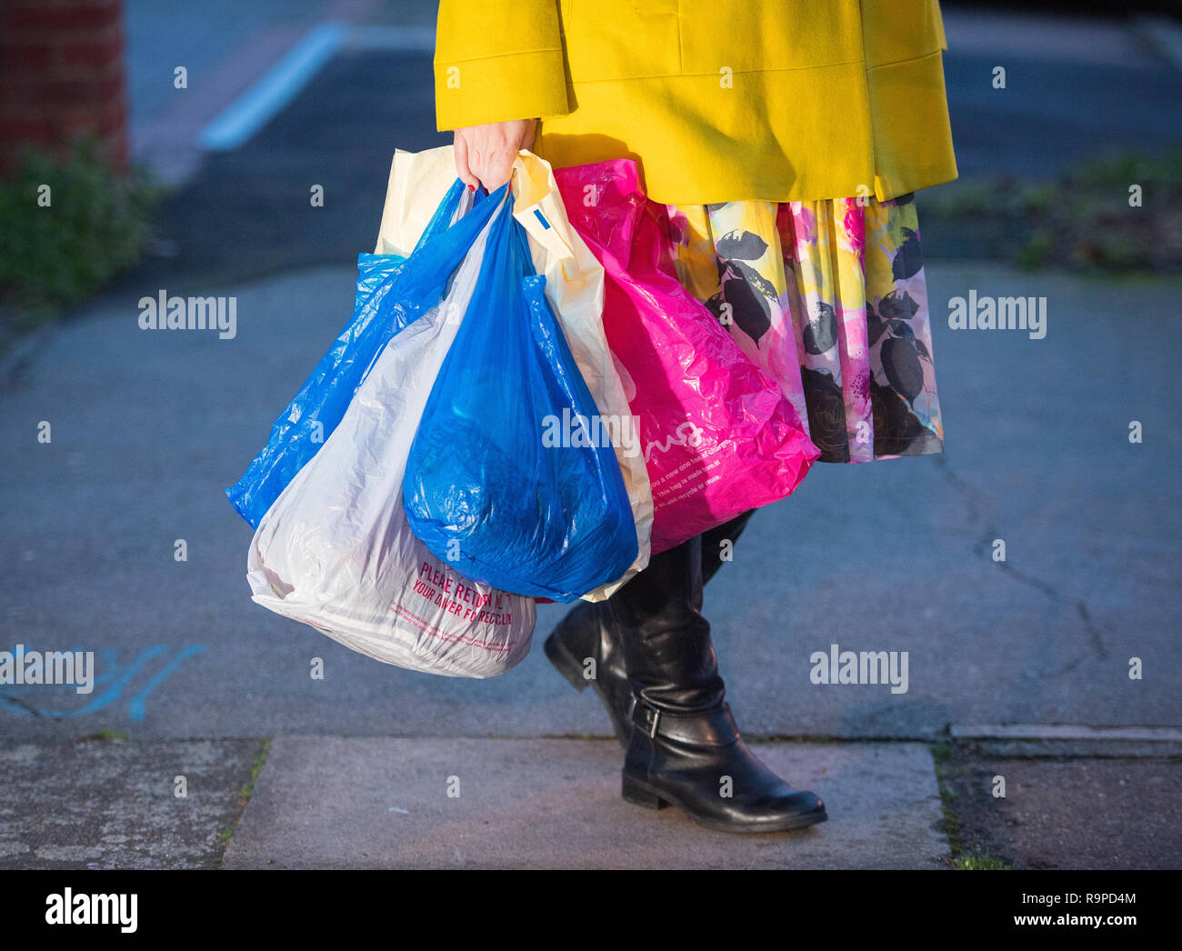 A woman carries shopping in plastic carrier bags in London. Shoppers ...