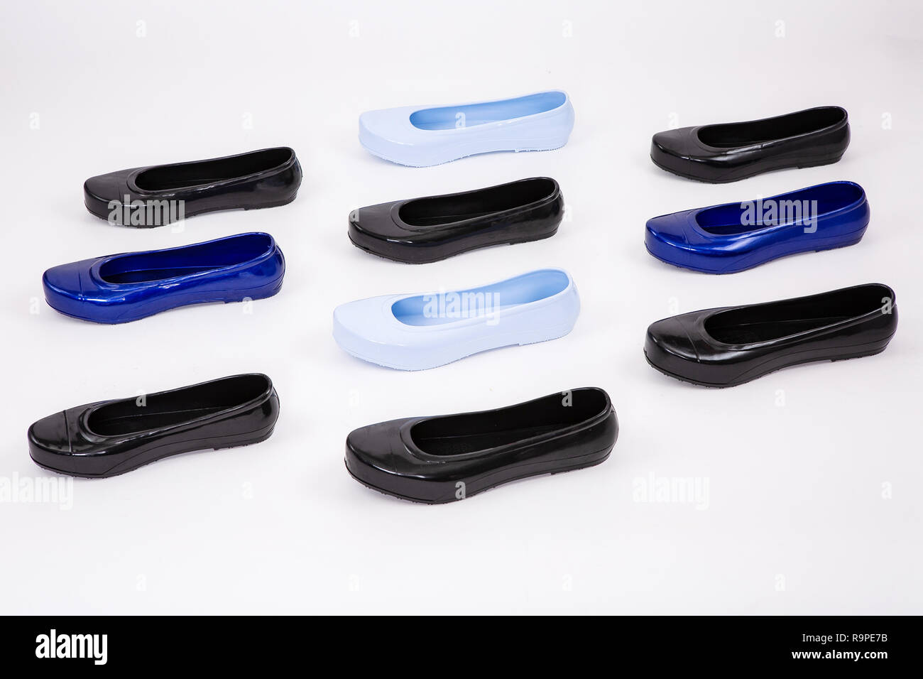 Blue, white, black rubber shoes are listed diagonally Stock Photo - Alamy
