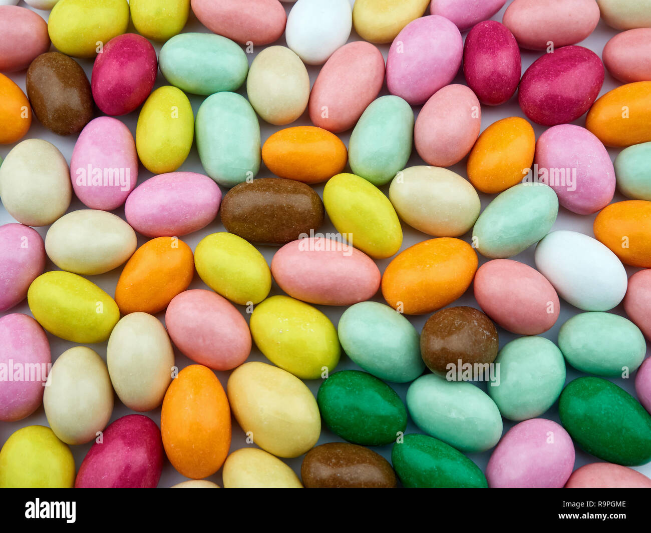 Bunch of colored sugared almonds closeup background Stock Photo - Alamy