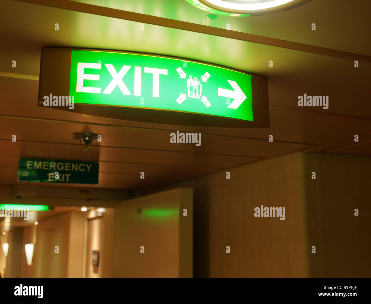 Illuminated Emergency Exit sign in the hotel corridor Stock Photo - Alamy