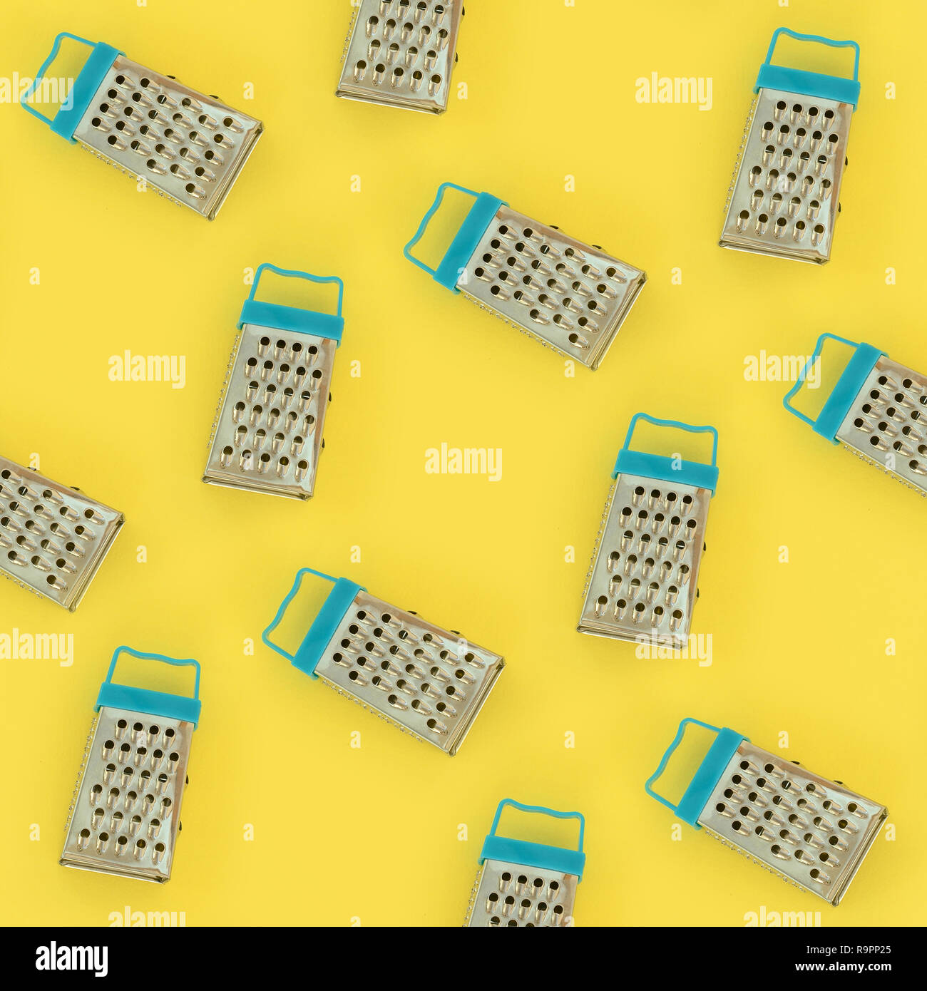 Small stainless steel graters lies on a pastel colored paper. Kitchen ...