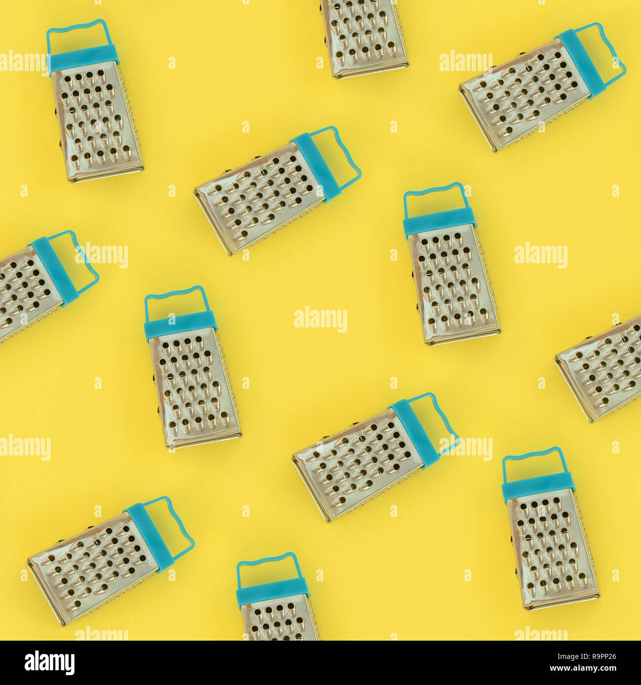 Small stainless steel graters lies on a pastel colored paper. Kitchen ...