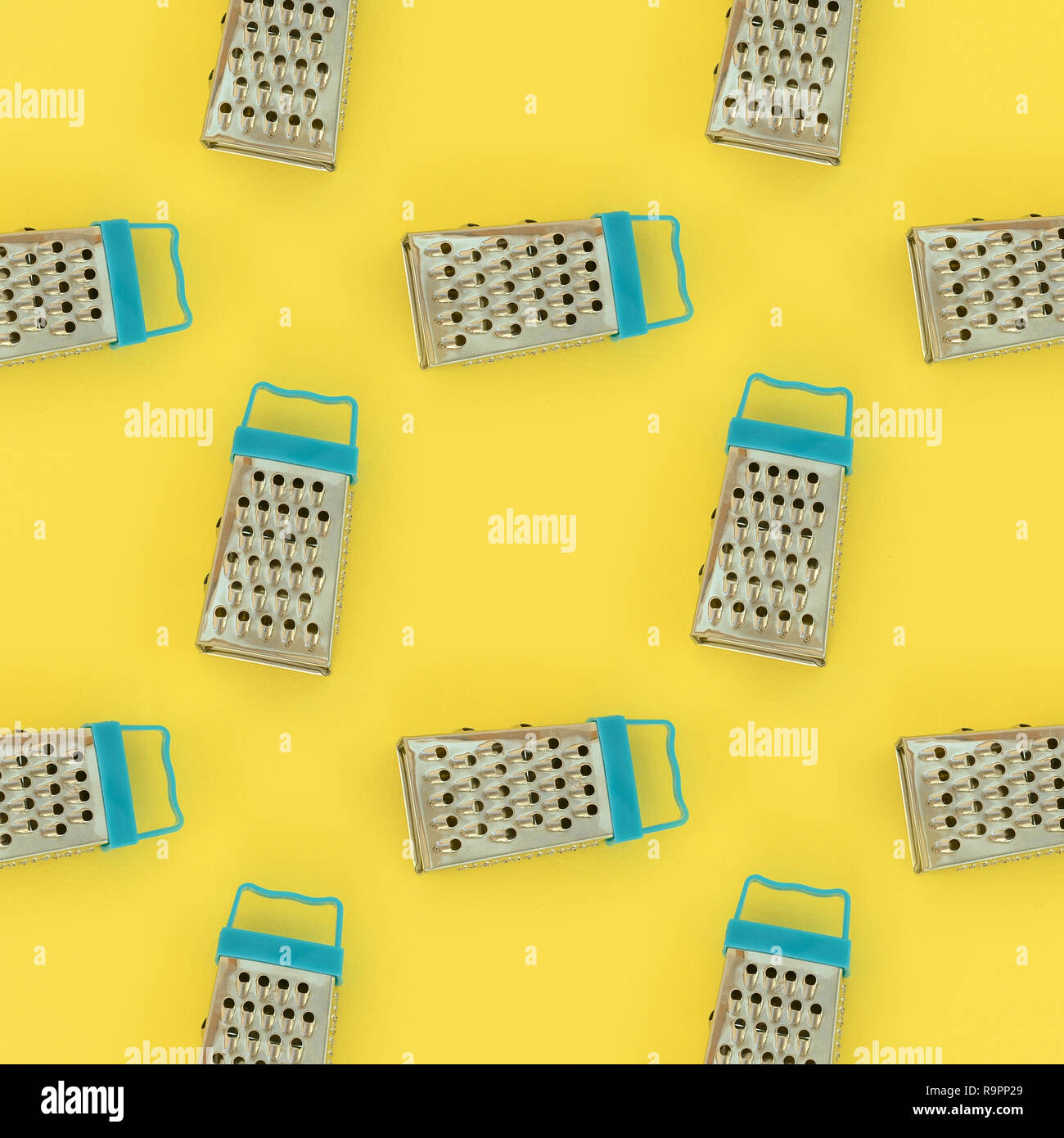 Small stainless steel graters lies on a pastel colored paper. Kitchen ...