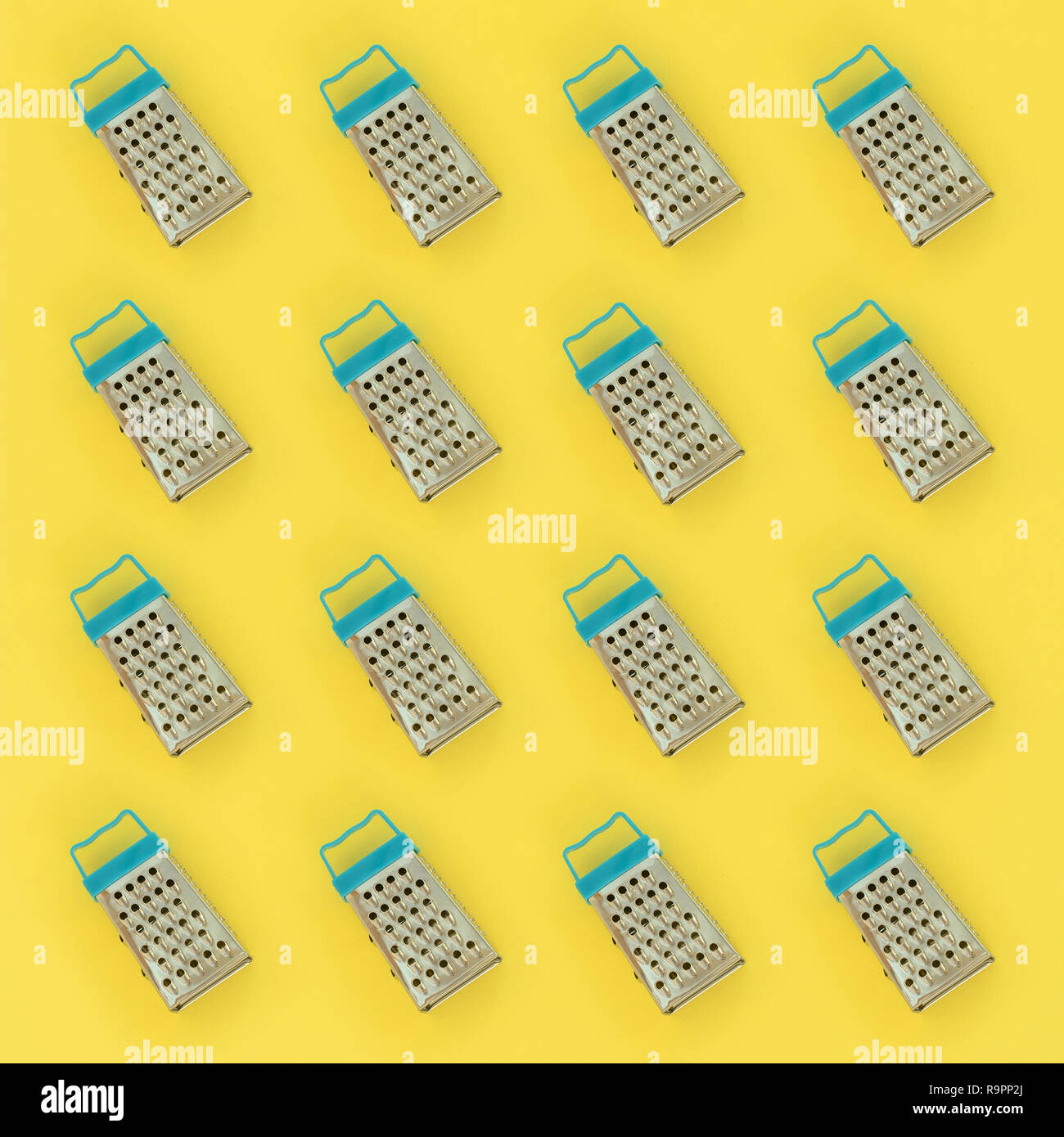 Small stainless steel graters lies on a pastel colored paper. Kitchen ...