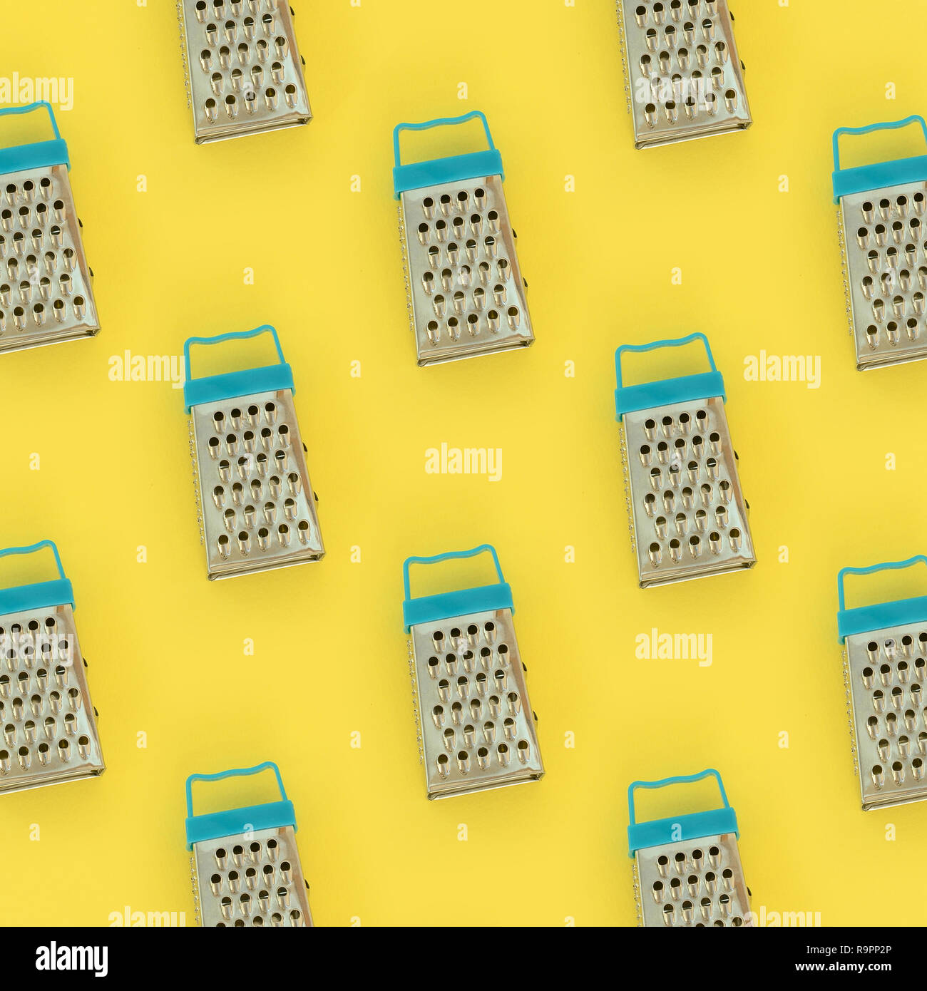 Small stainless steel graters lies on a pastel colored paper. Kitchen ...