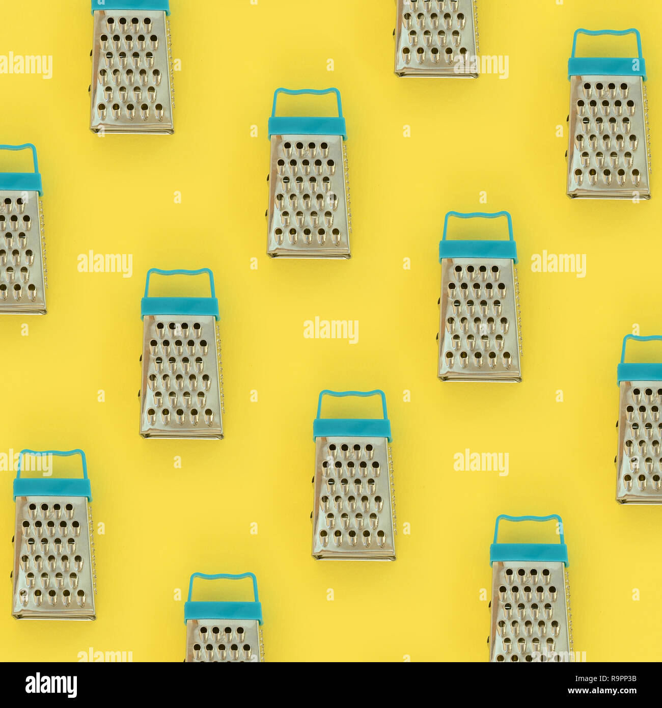 Small stainless steel graters lies on a pastel colored paper. Kitchen ...