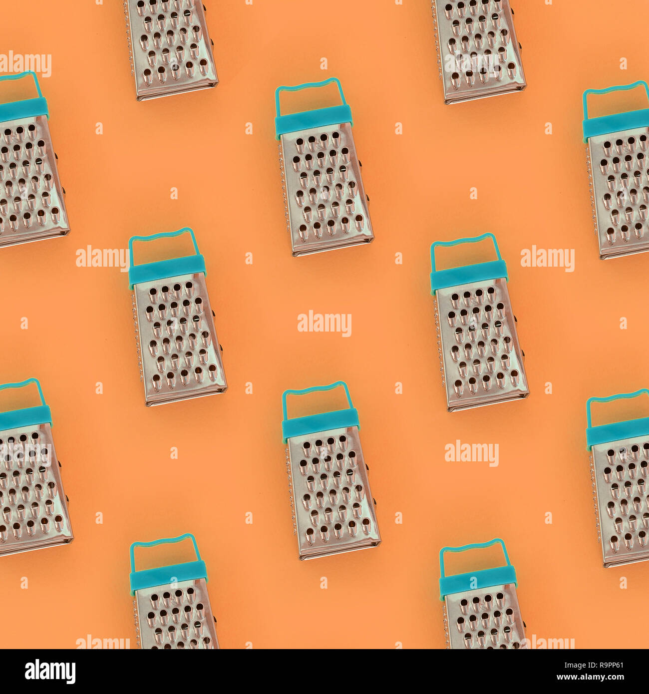 Small stainless steel graters lies on a pastel colored paper. Kitchen ...