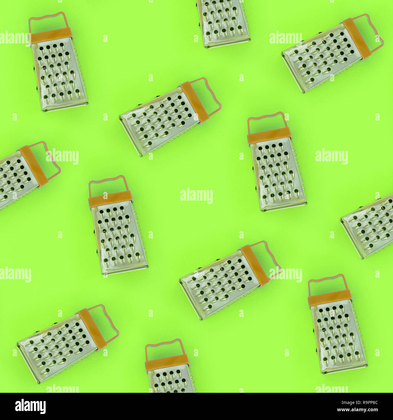 Small stainless steel graters lies on a pastel colored paper. Kitchen ...