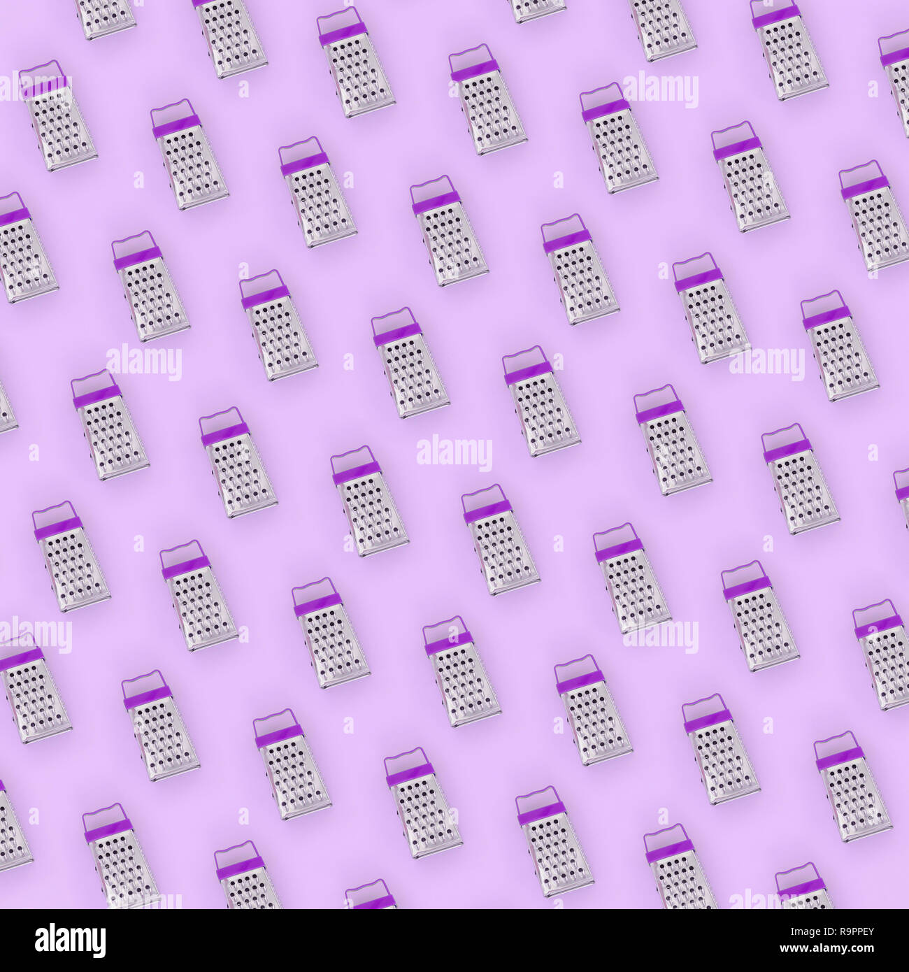 Small stainless steel graters lies on a pastel colored paper. Kitchen ...