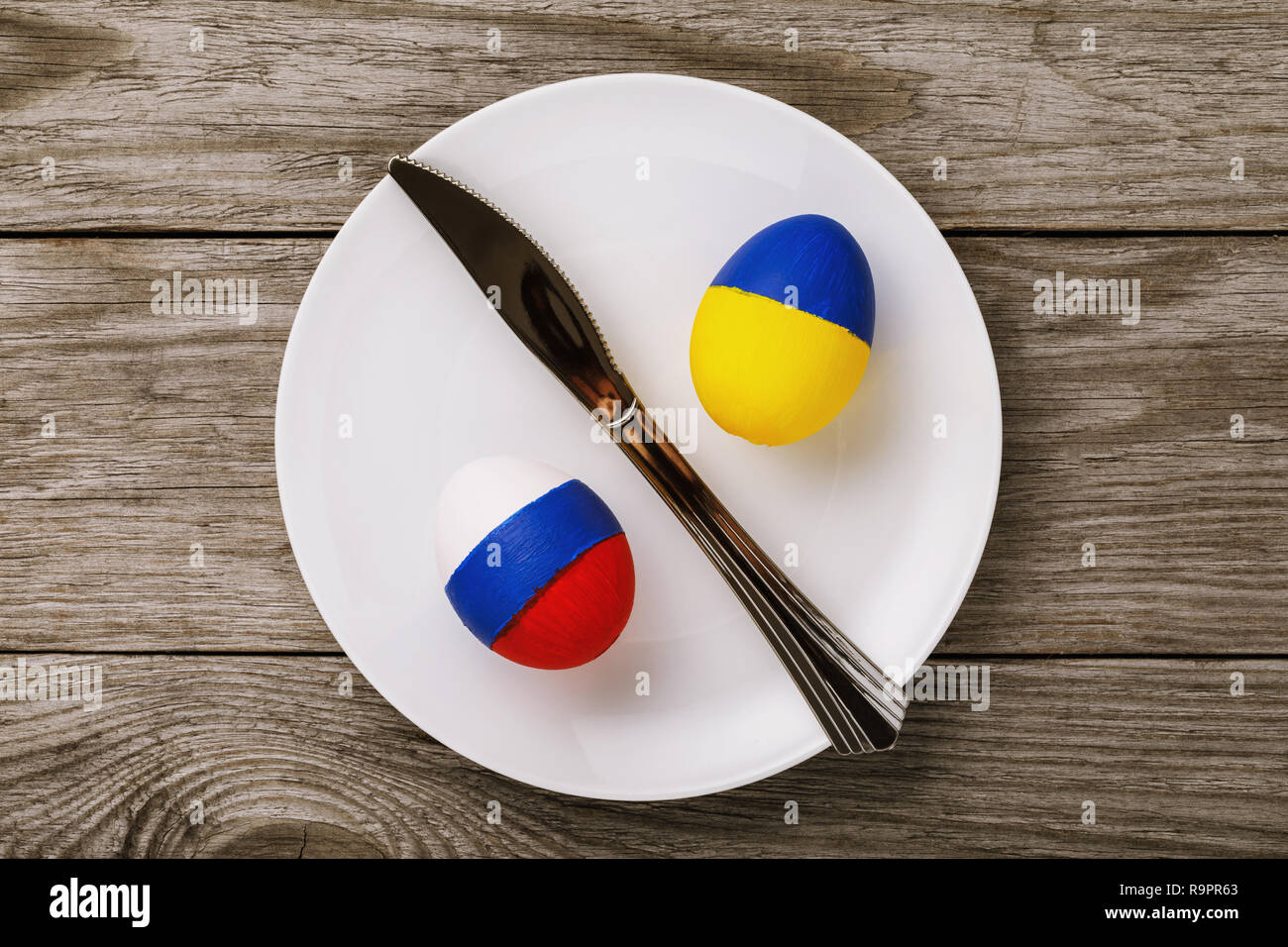 Two Easter eggs painted in the color of the flags of Russia and Ukraine ...