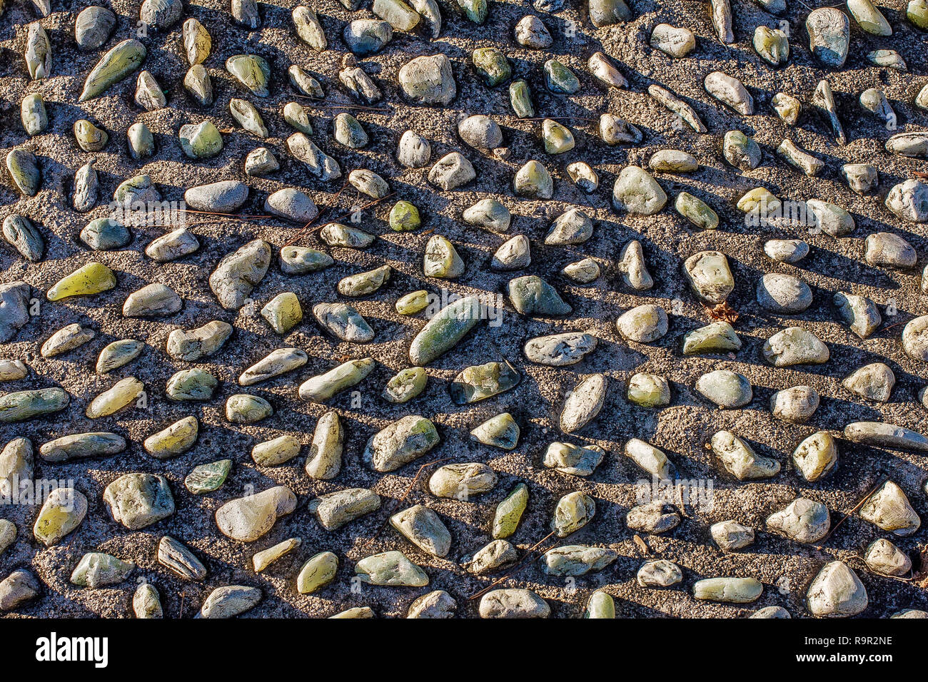 various stones stuck in concrete Stock Photo - Alamy