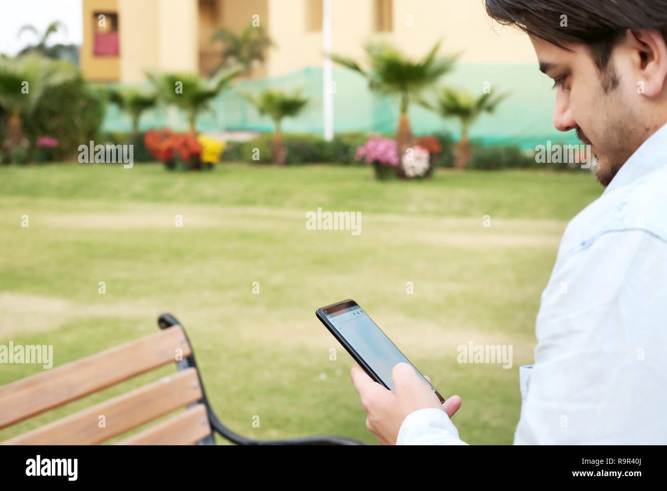 Boy is using smartphone on the park Stock Photo - Alamy