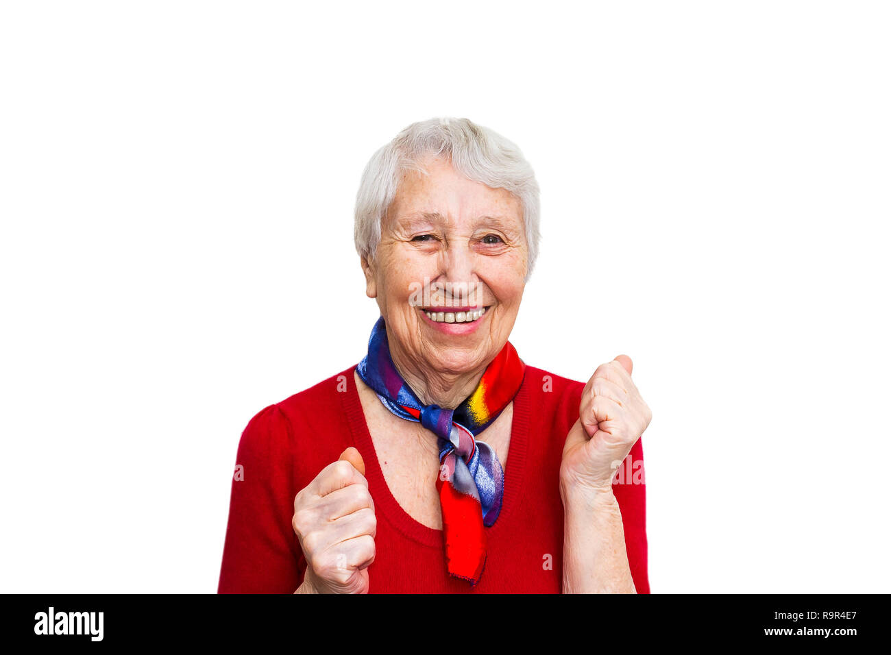 Old smiling woman with happy expression on her face on red studio ...