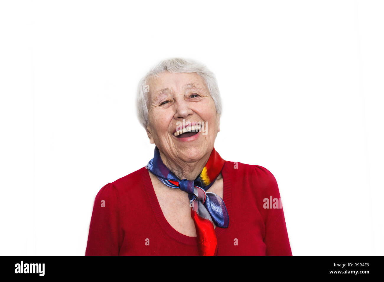 Old smiling woman with happy expression on her face on red studio ...