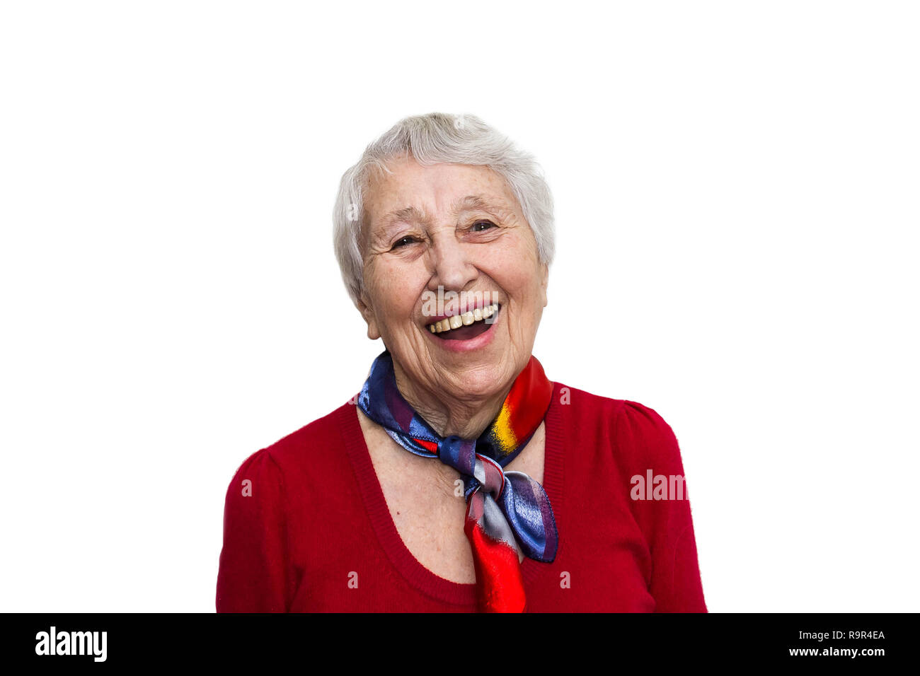 Old smiling woman with happy expression on her face on red studio ...