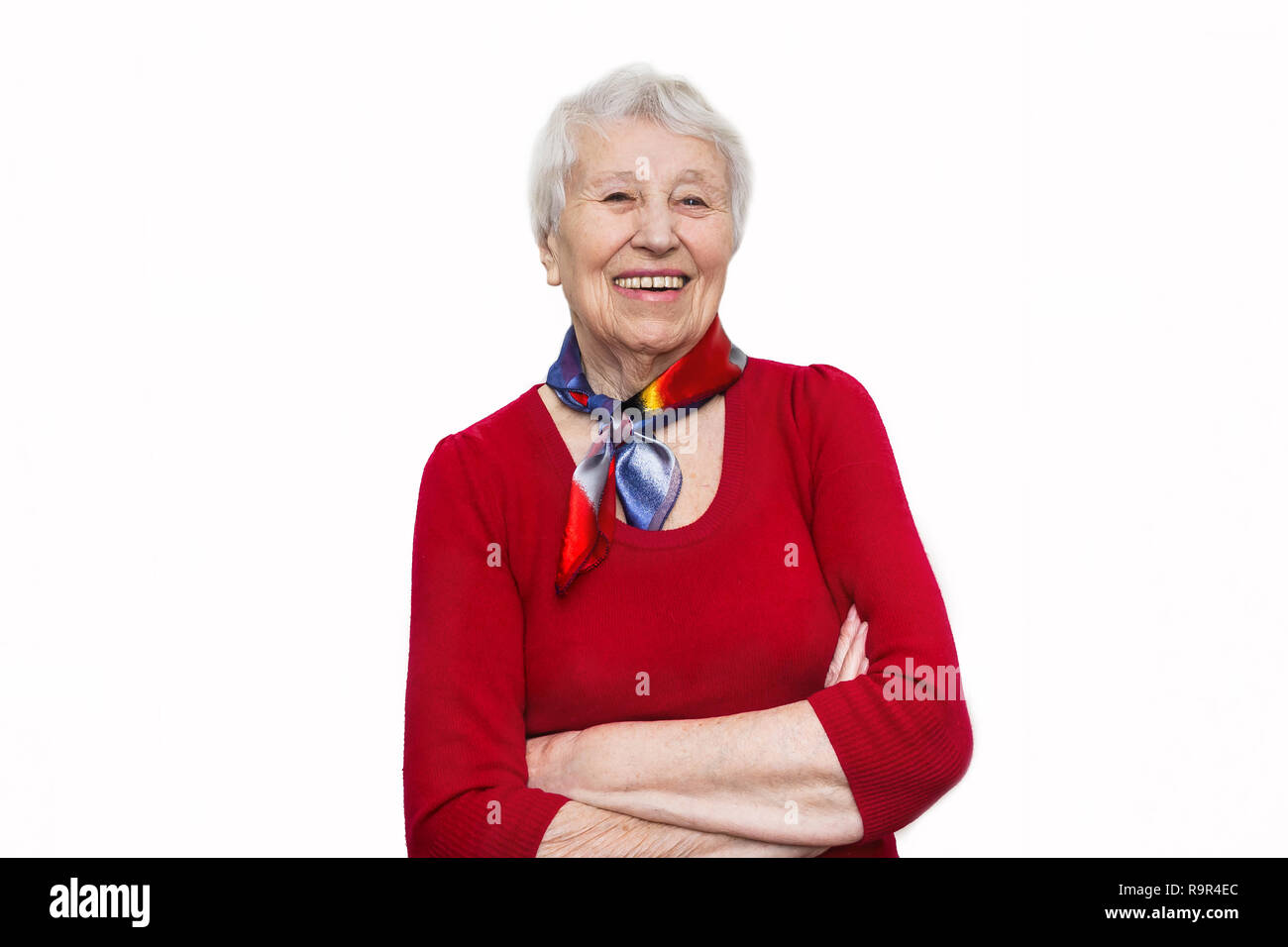Old smiling woman with happy expression on her face on red studio ...