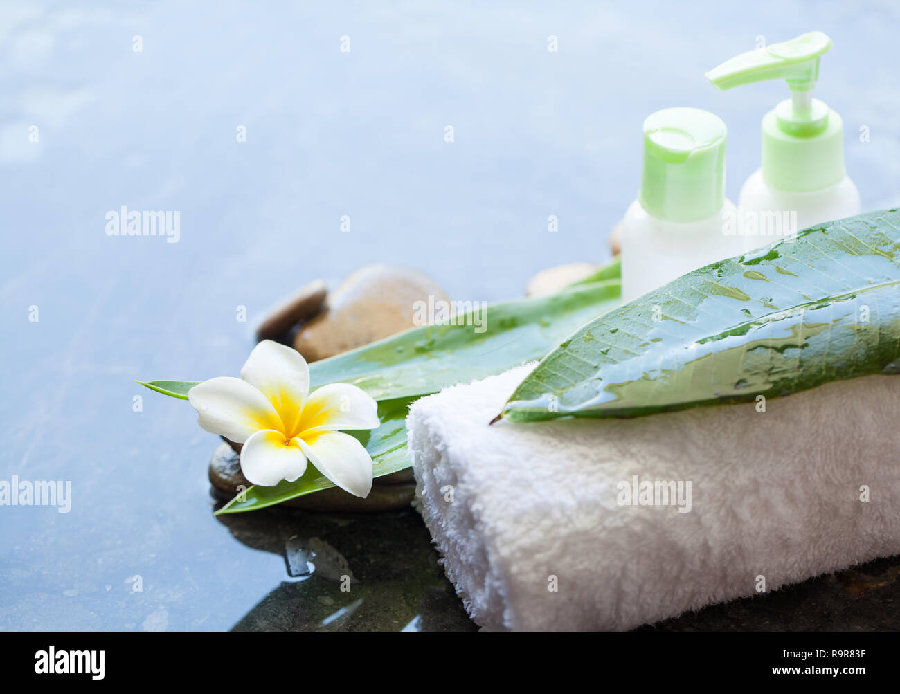 stones, towel, bottles, leaves for massage treatment on dark background ...