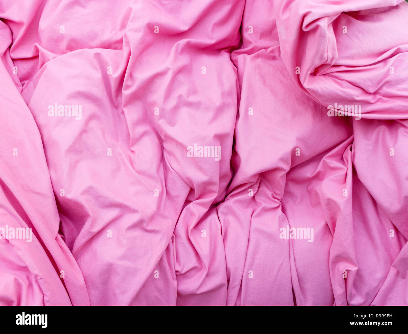 Fabric textures and patterns concept. Detailed closeup of pink creased ...