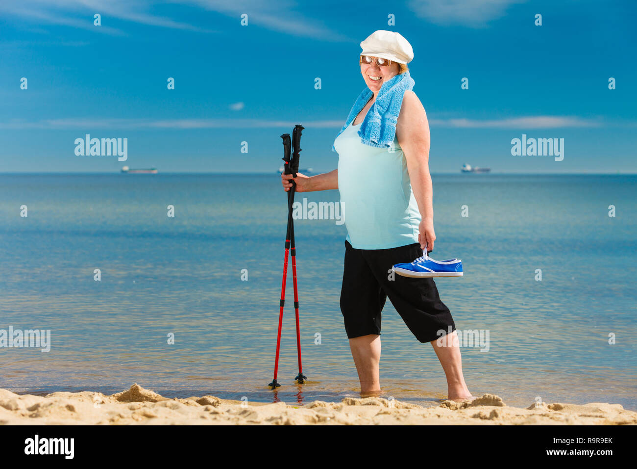 Senior woman practicing nordic walking on sea shore, Active elderly ...