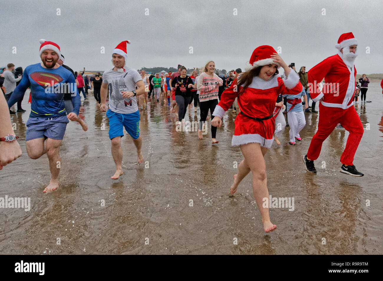 Pictured: People in festive fancy dress costumes run to the freezing ...