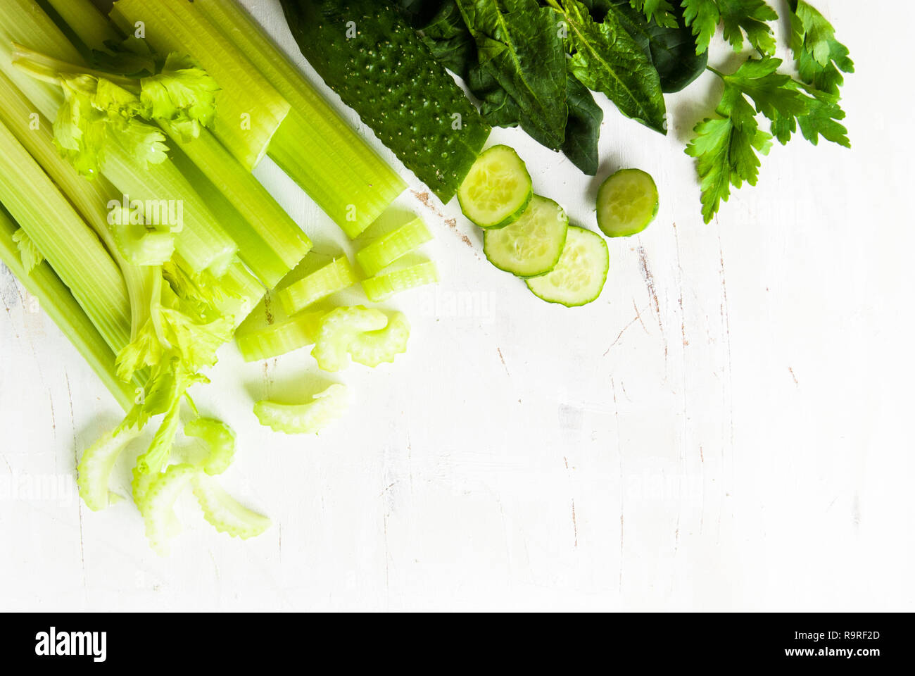 Green vegetable background with celery, cucumber, spinach and herbs on ...