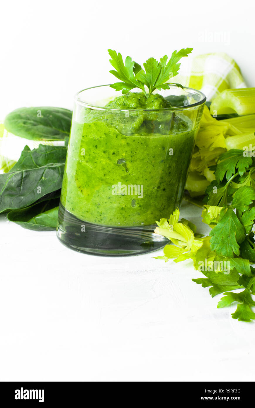 Green vegetable smoothie with celery, spinach and herbs in a ...