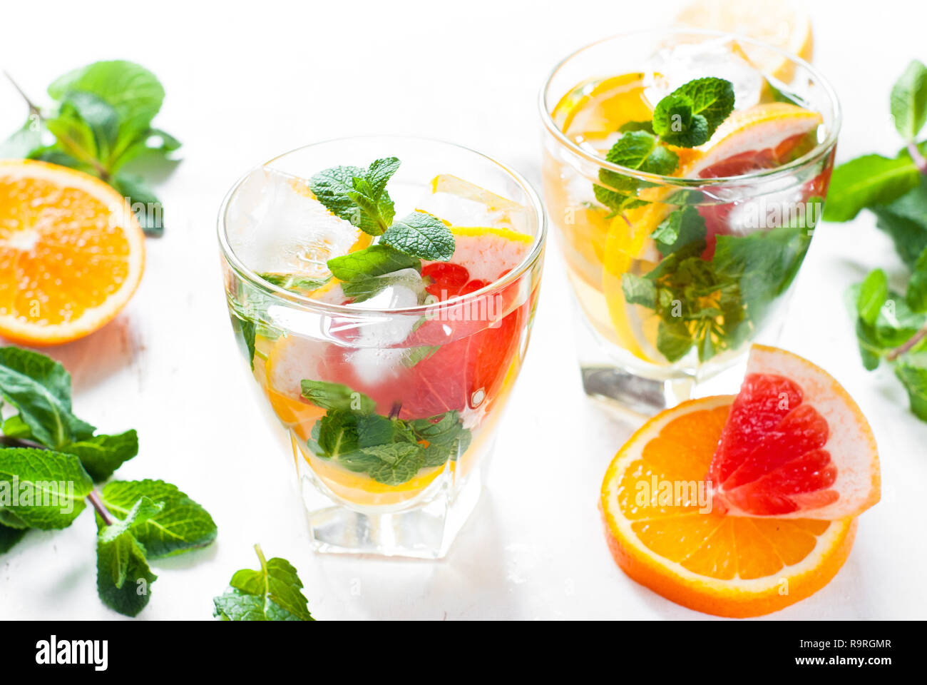 Ice citrus drink with lemon, orange, grapefruit and mint at white Stock ...