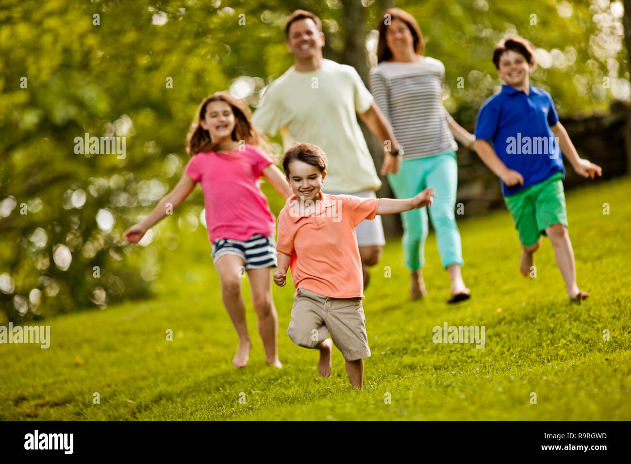 Happy family running on the lawn Stock Photo - Alamy
