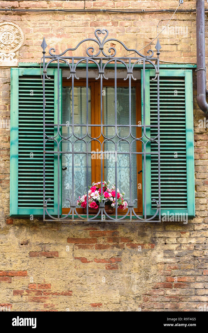 Traditional window with wooden shutters of old house in Siena. Italy ...