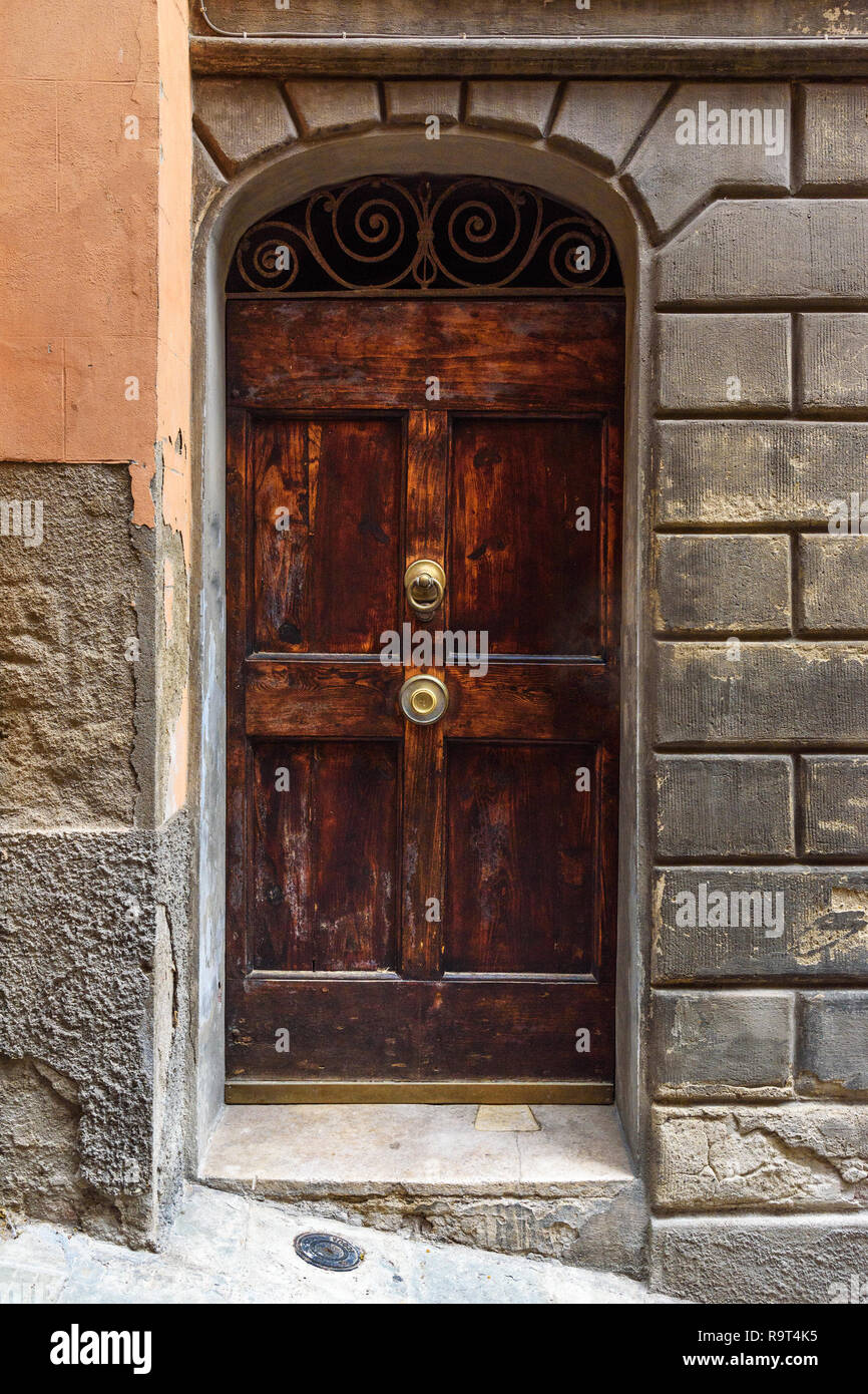 Traditional wooden arch door on medieval brick building in Siena. Italy ...