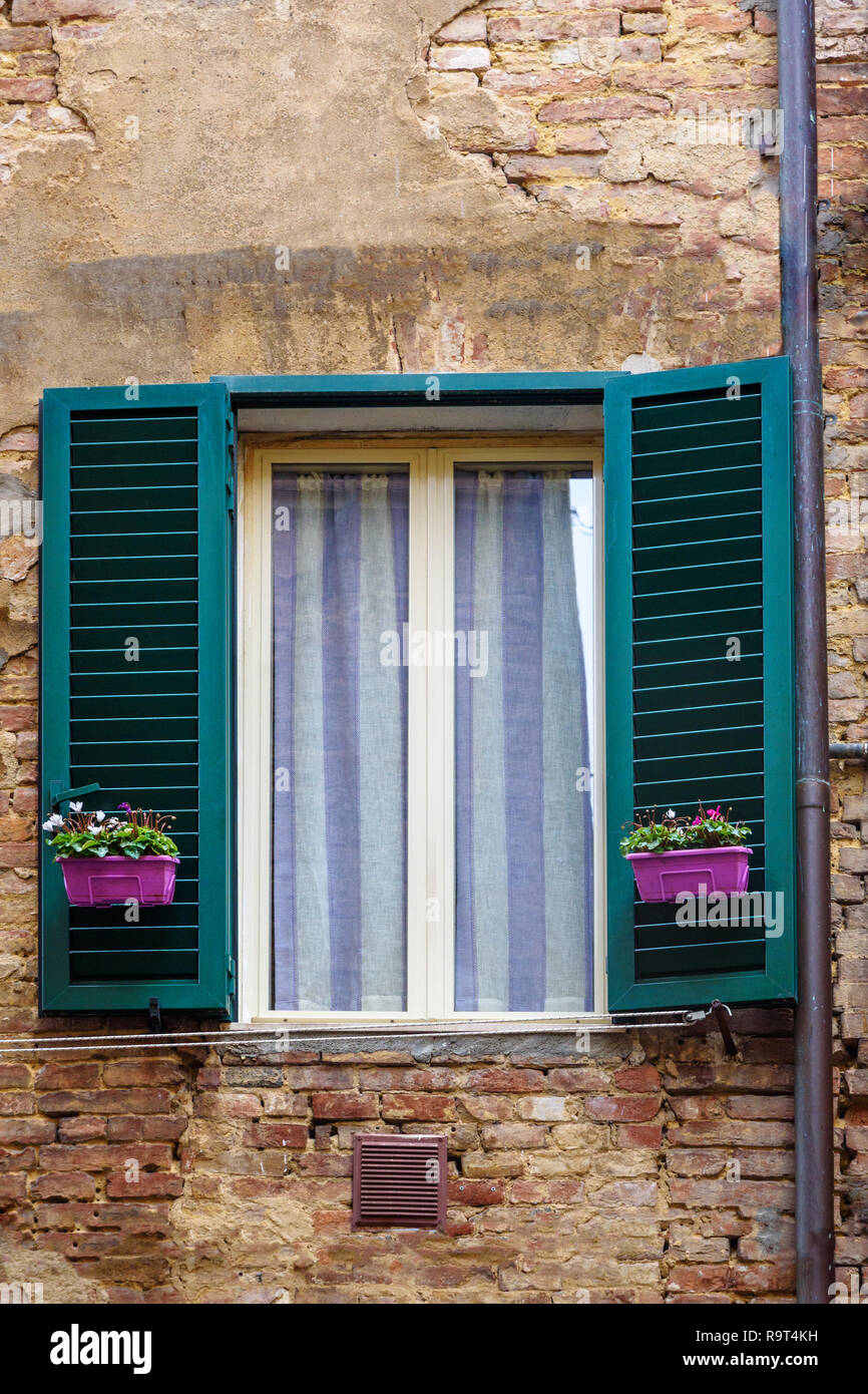 Traditional window with wooden shutters of old house in Siena. Italy ...