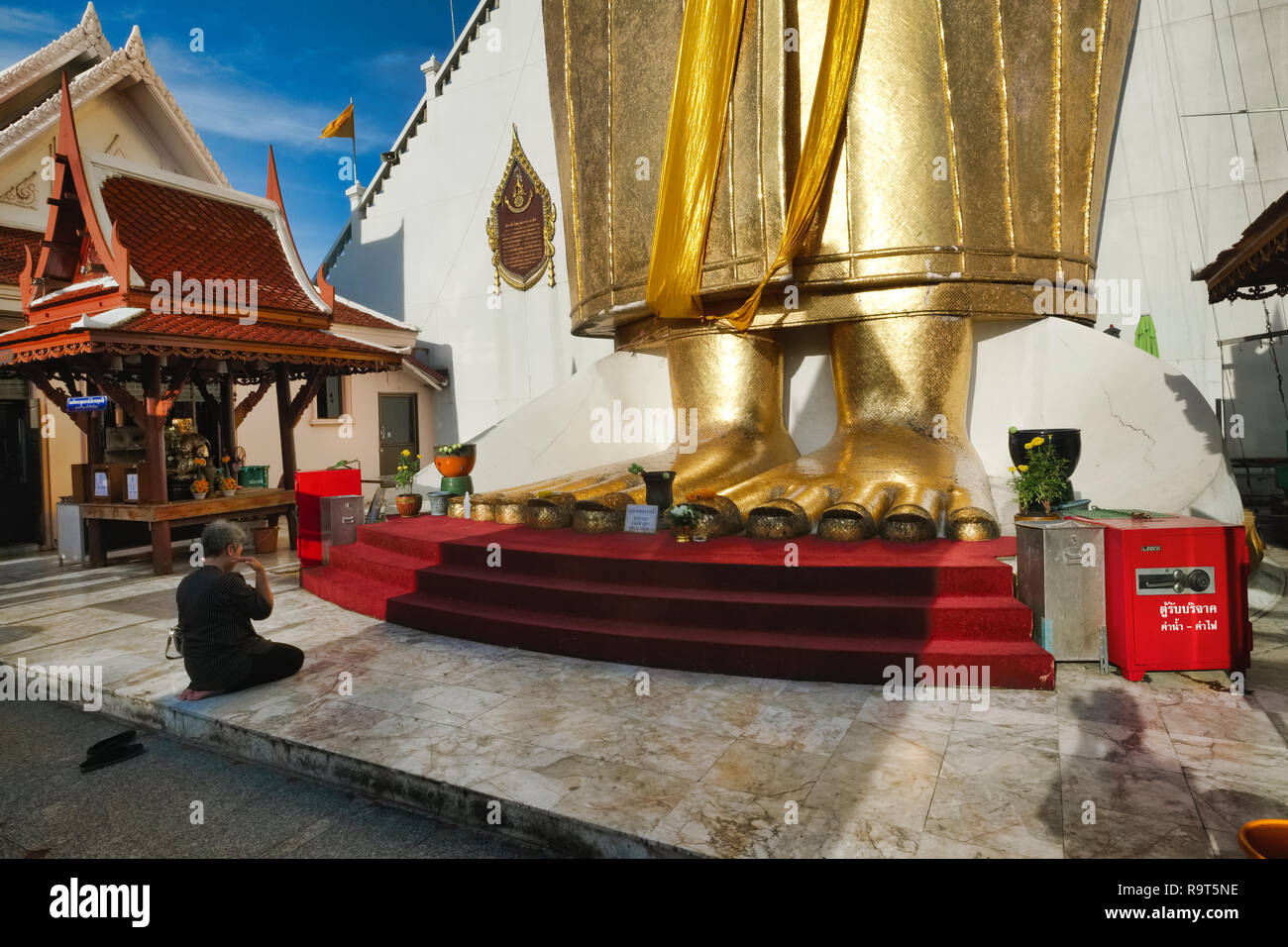 A woman praying at the feet of the giant Buddha statue in Wat ...