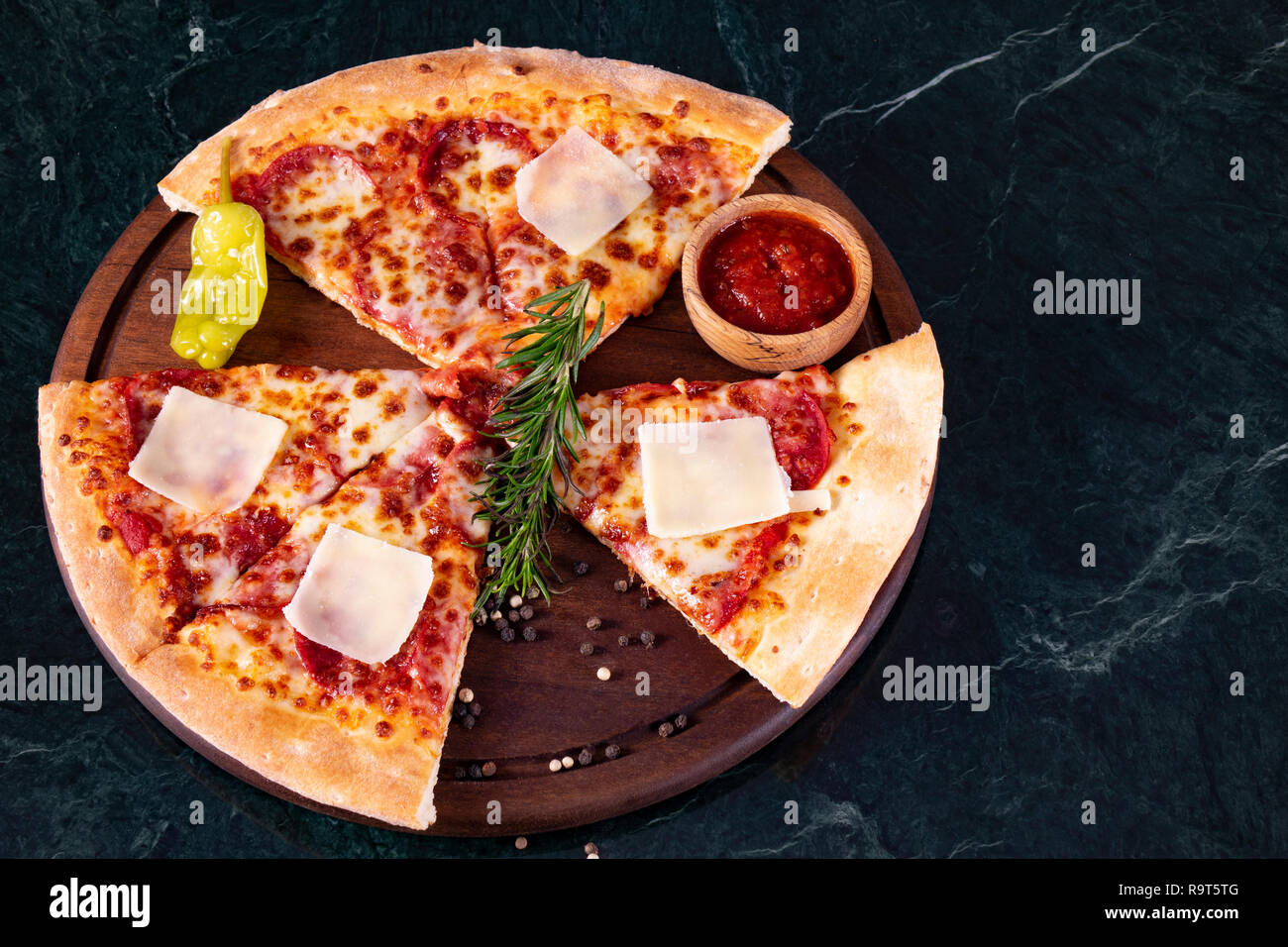 Delicious baked pizza served on black marble table Stock Photo - Alamy