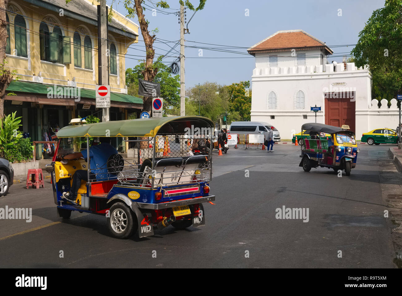 Two tuk-tuks in Bangkok, Thailand, three-wheeled mini-taxis making a ...