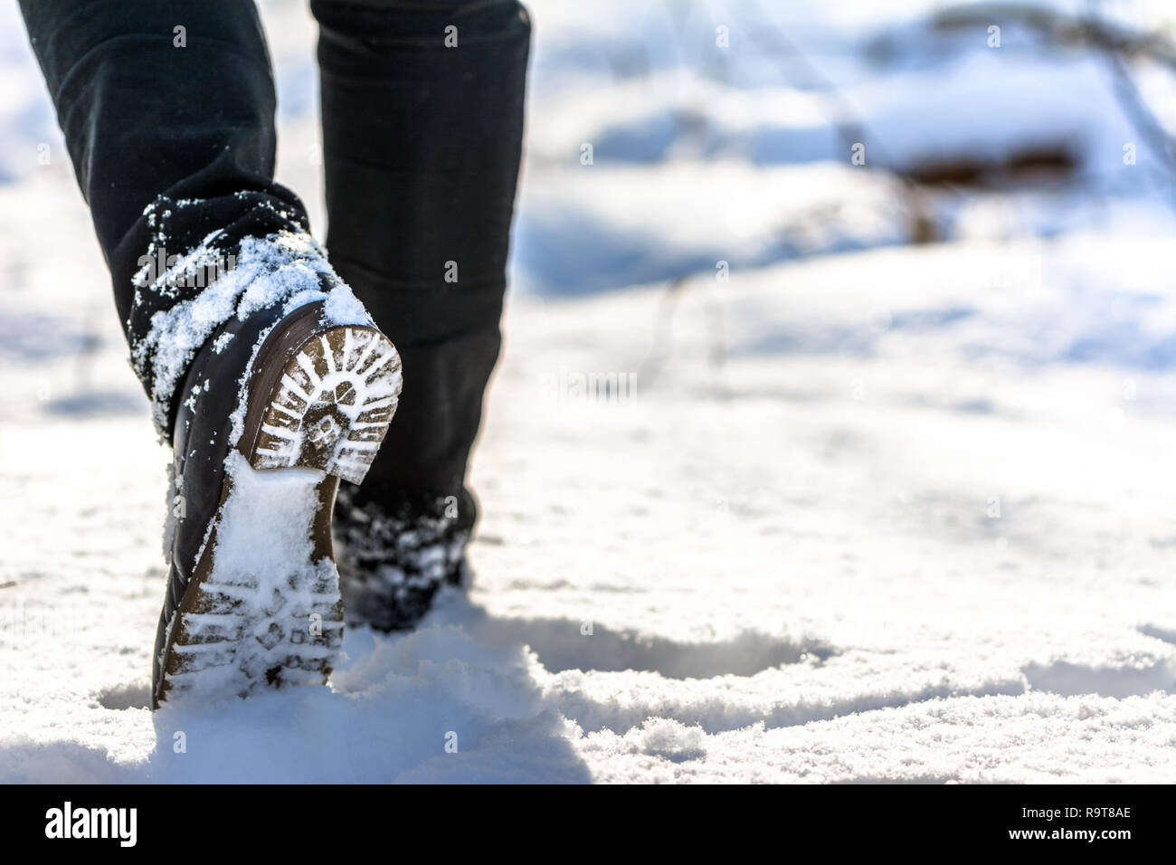 Female feet in black boots and jeans, winter walking in snow Stock ...