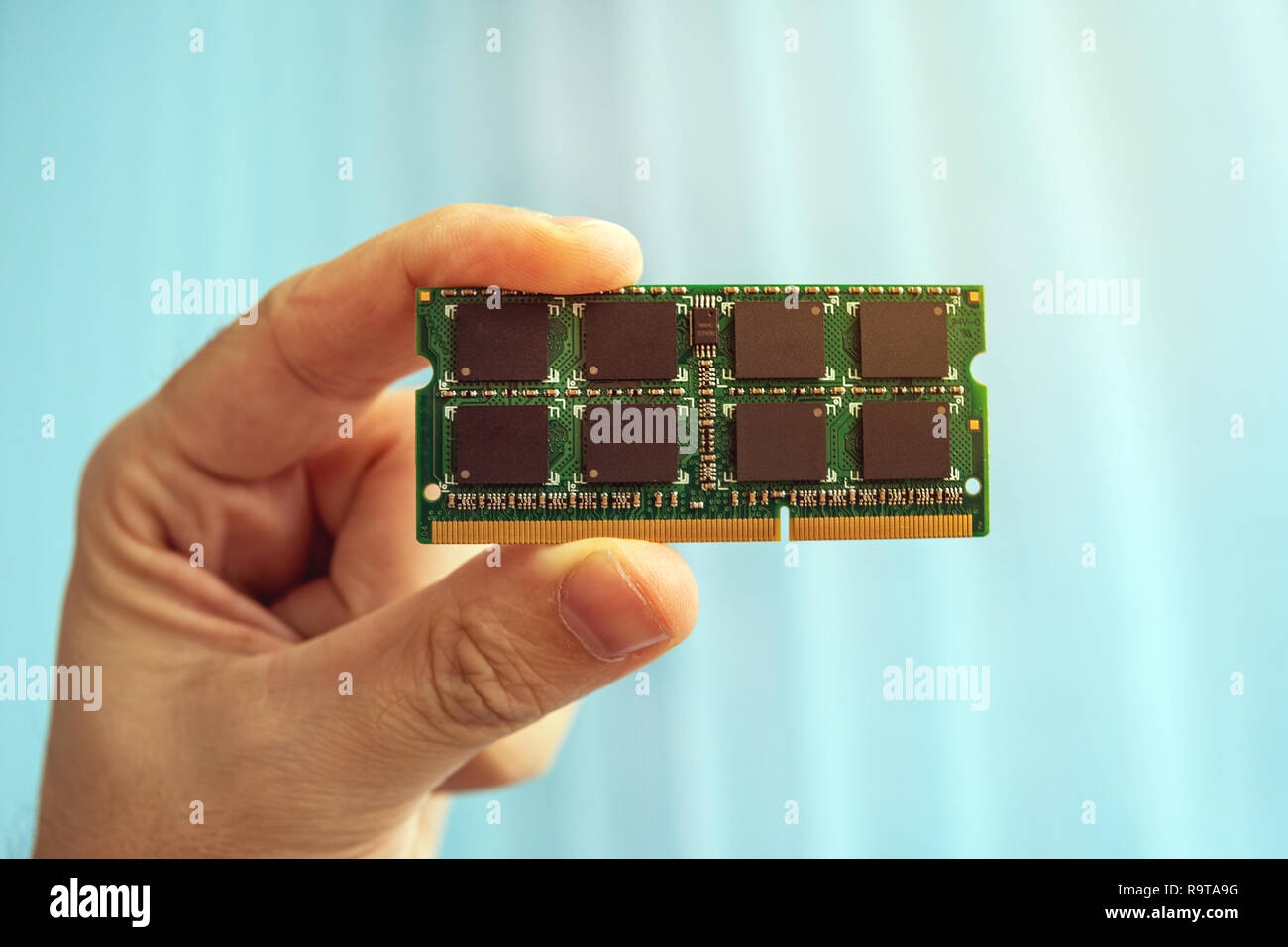 Human hand placing the RAM memory card on laptop computer motherboard ...