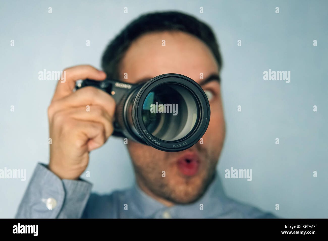 Portrait of excited surprised photographer with camera at hand ...