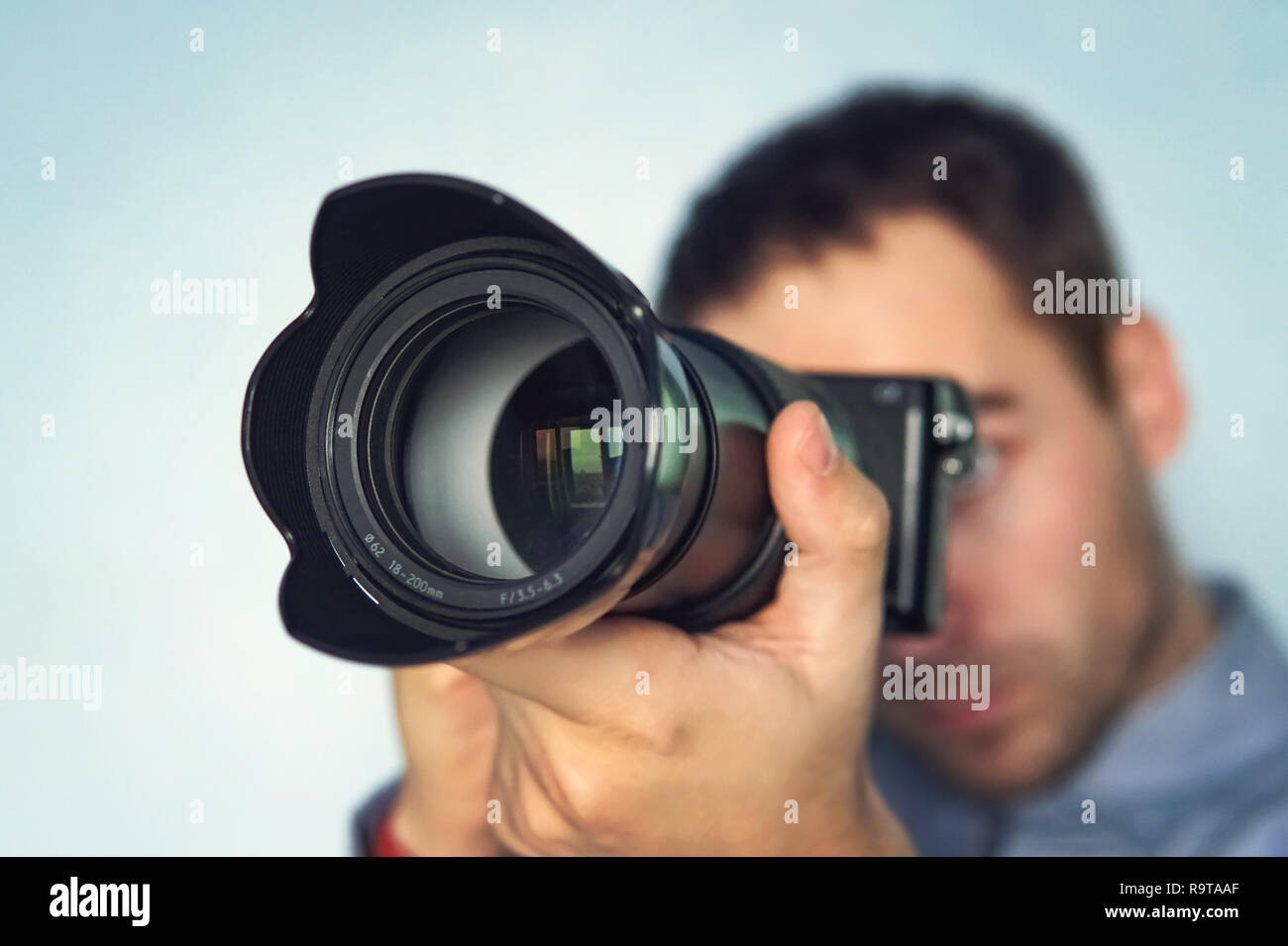 male photographer hold camera in his hands. Mirrorless camera close up ...