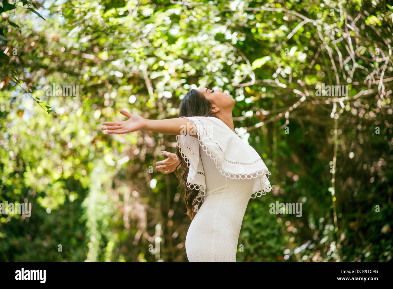 Side view of a happy woman arms outstretched in the forest Stock Photo ...