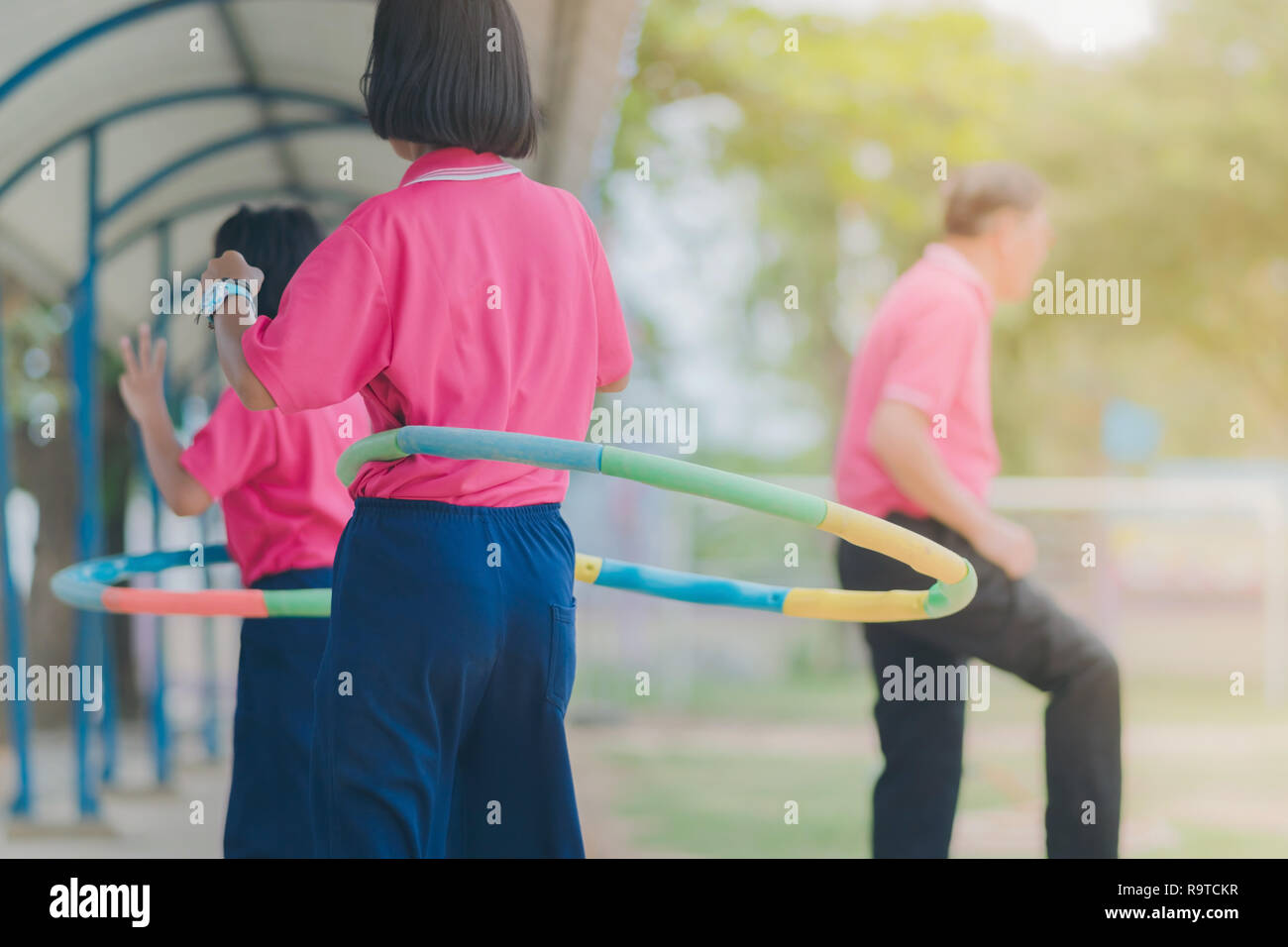 Female students doing exercise with a hula-hoop for a good healthy at ...