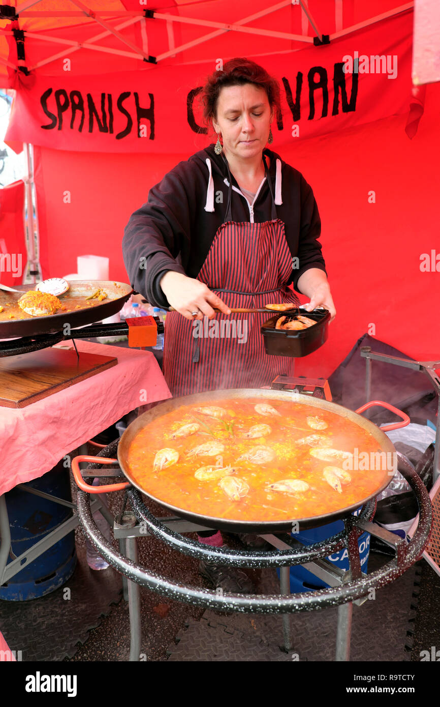 A Female chef preparing shrimp paella rice dish cooking outside at ...