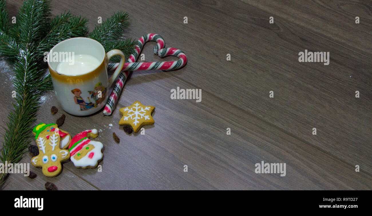 Gingerbread colorful cookies with glass of milk, lolipop and branch of ...