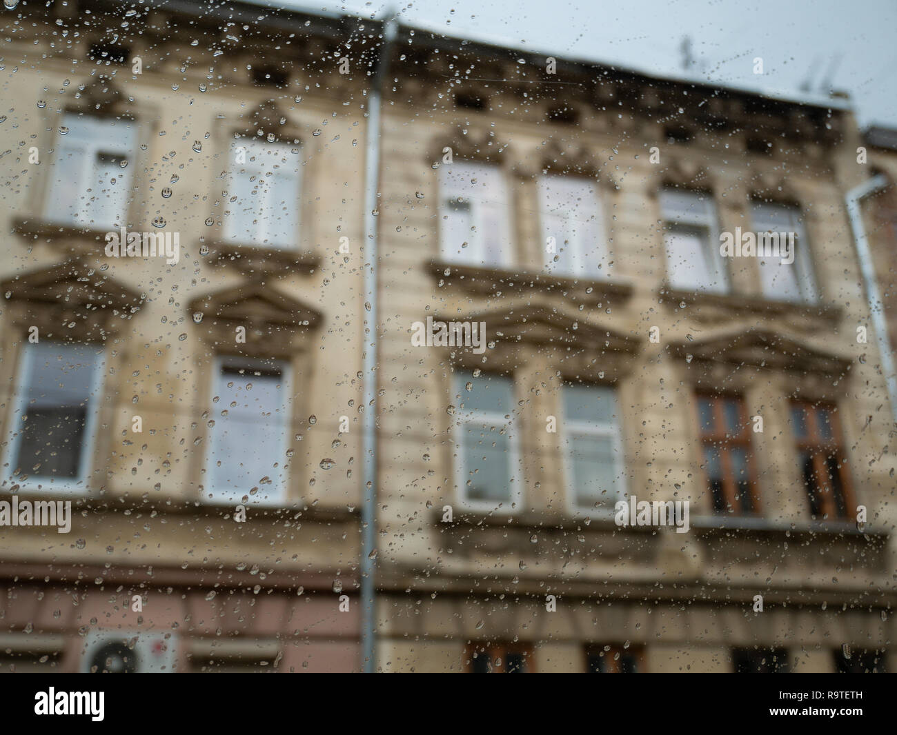closeup of clear bus side window with droplets and out of focus blurred ...