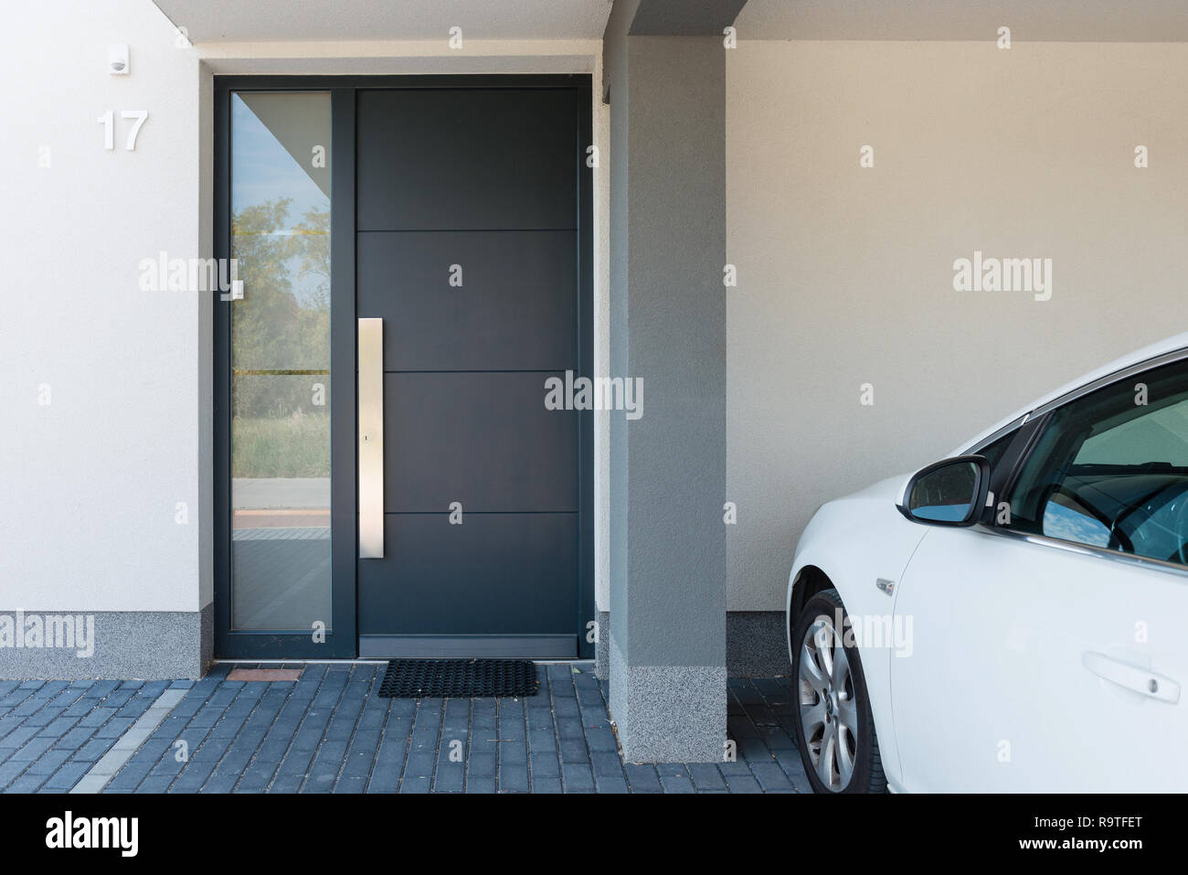 Modern house entrance with parking car next to it Stock Photo - Alamy