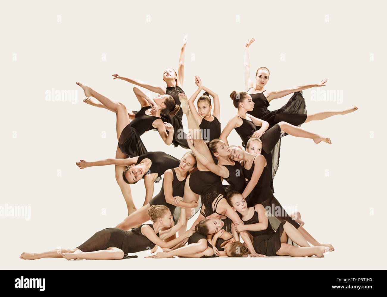 The group of modern ballet dancers dancing on gray studio background ...