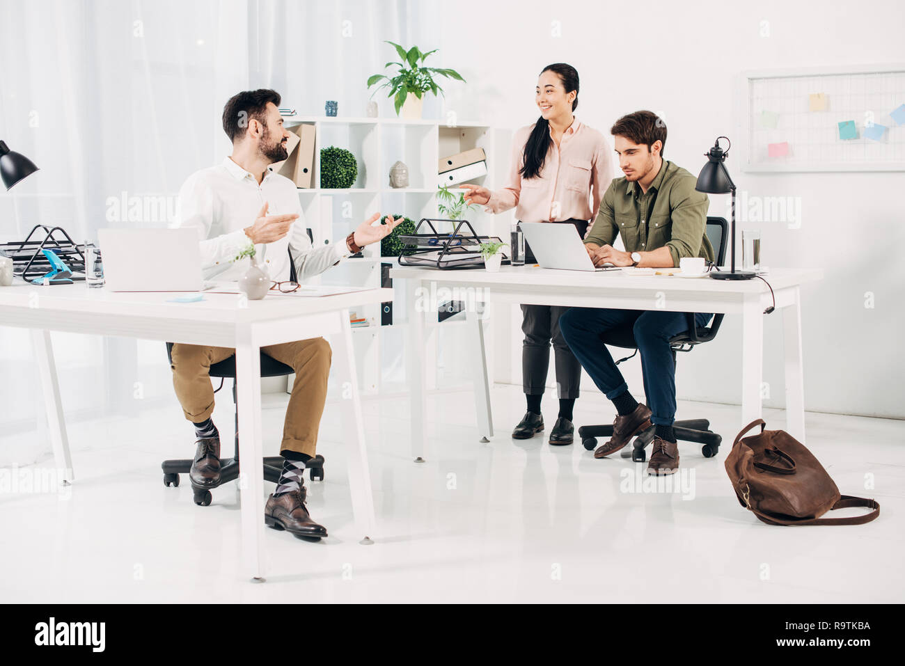 Office colleagues smiling and talking in modern office Stock Photo - Alamy